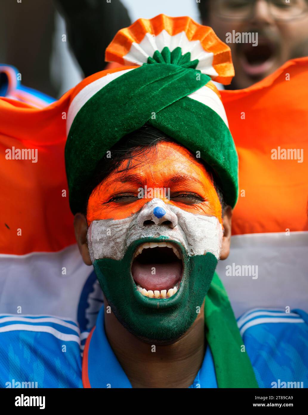 An Indian fan with the colors of the Indian national flag painted on ...