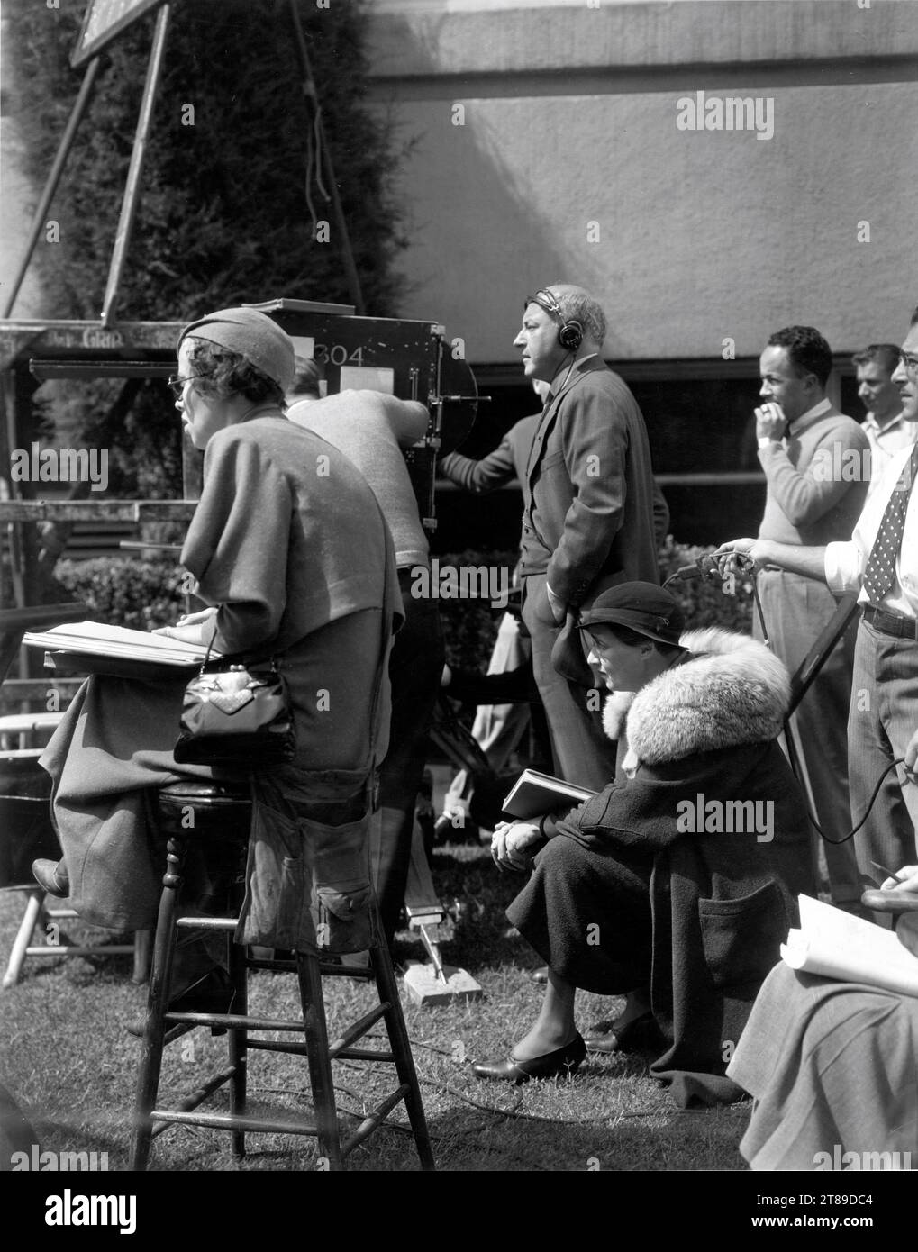 Director CECIL B. DeMILLE wearing headphones and Cinematographer J ...