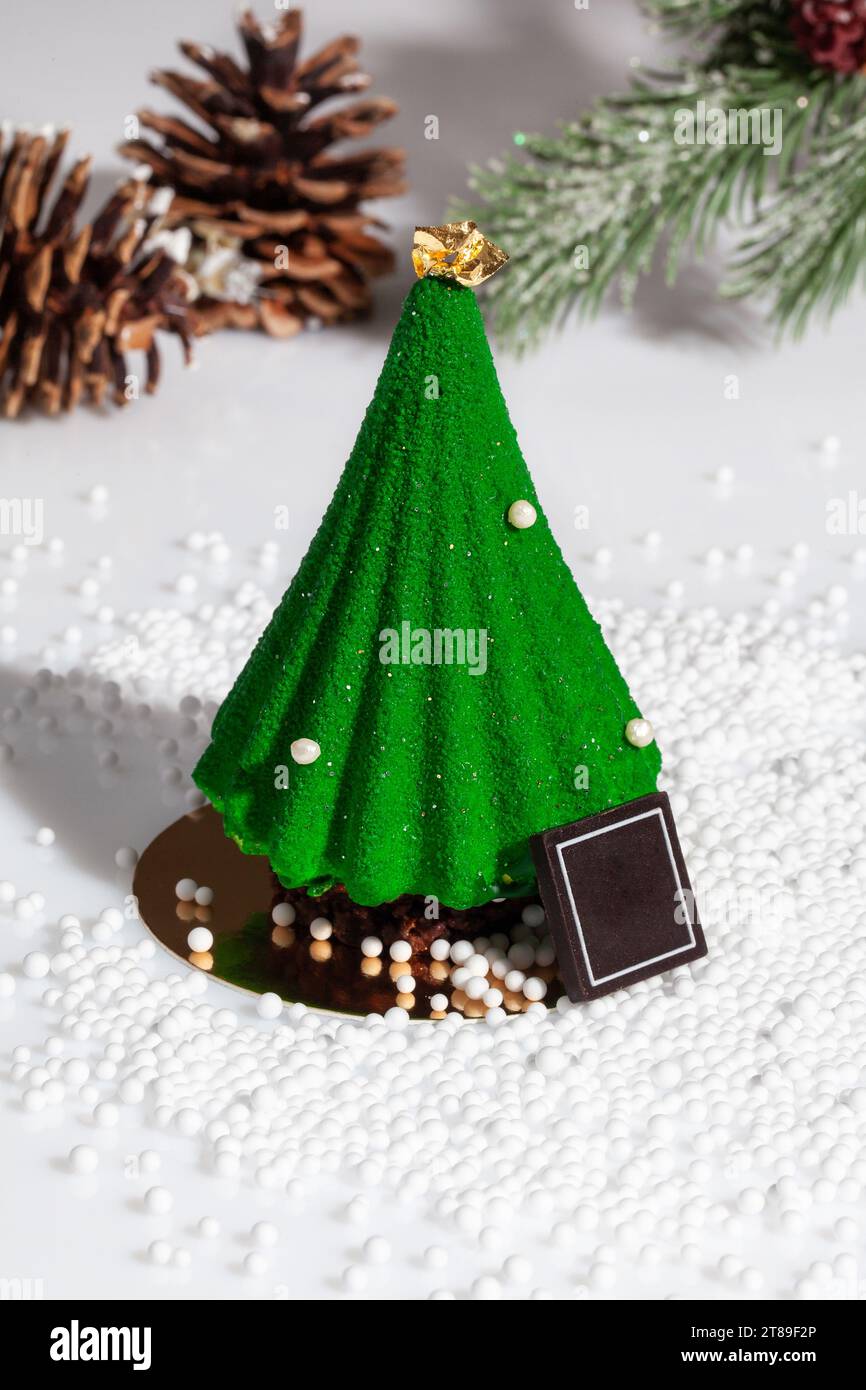 Green Christmas tree shaped cake with fir branch and cones Stock Photo ...