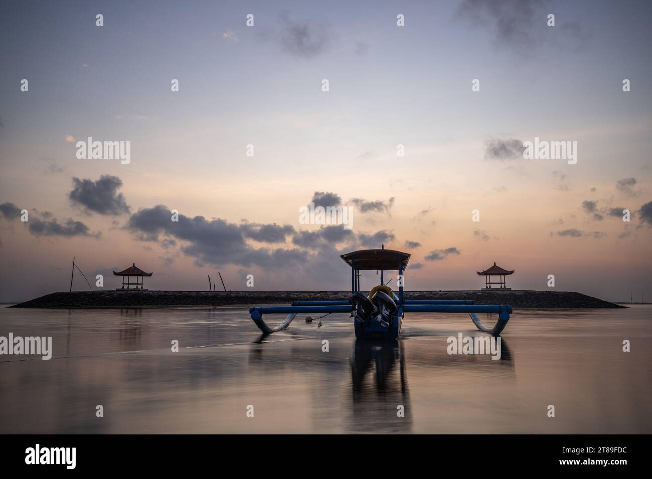 Sunrise at the sandy beach of Sanur. Temple in the water. Traditional ...