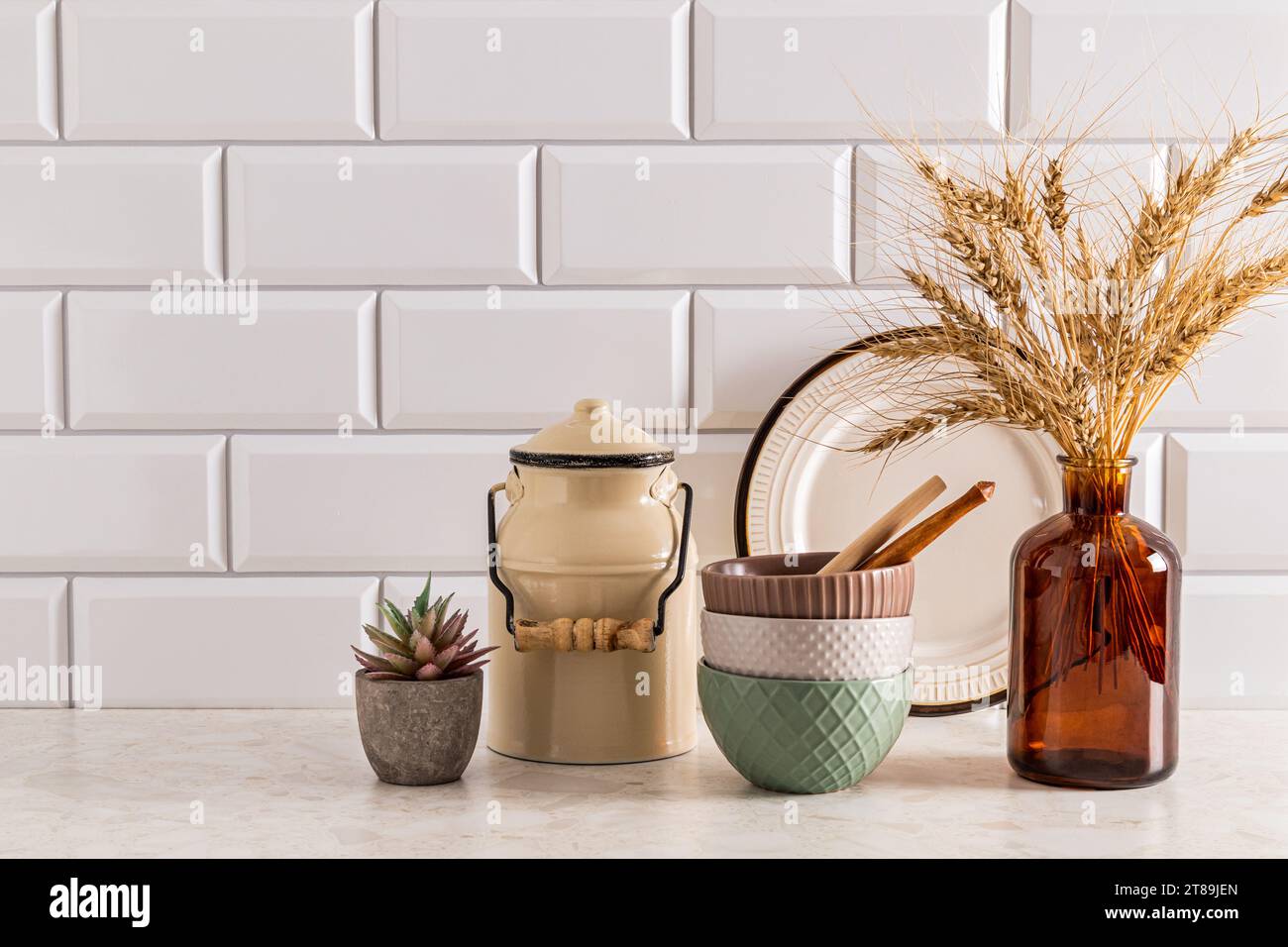 Trendy kitchen utensils and decorative vase with dry branches on stone ...