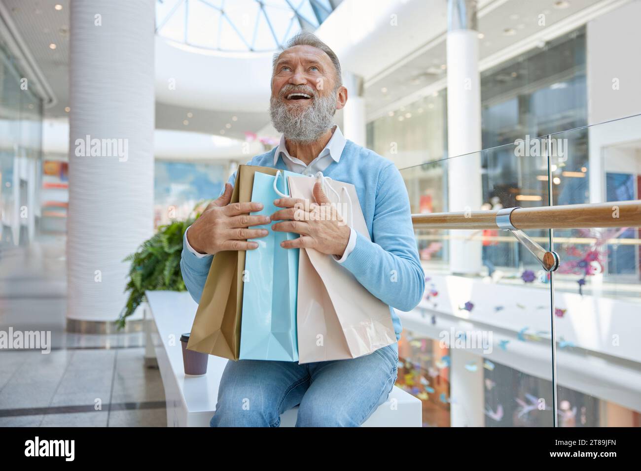 Happy fashion elderly man with purchases s in shopping mall Stock Photo ...