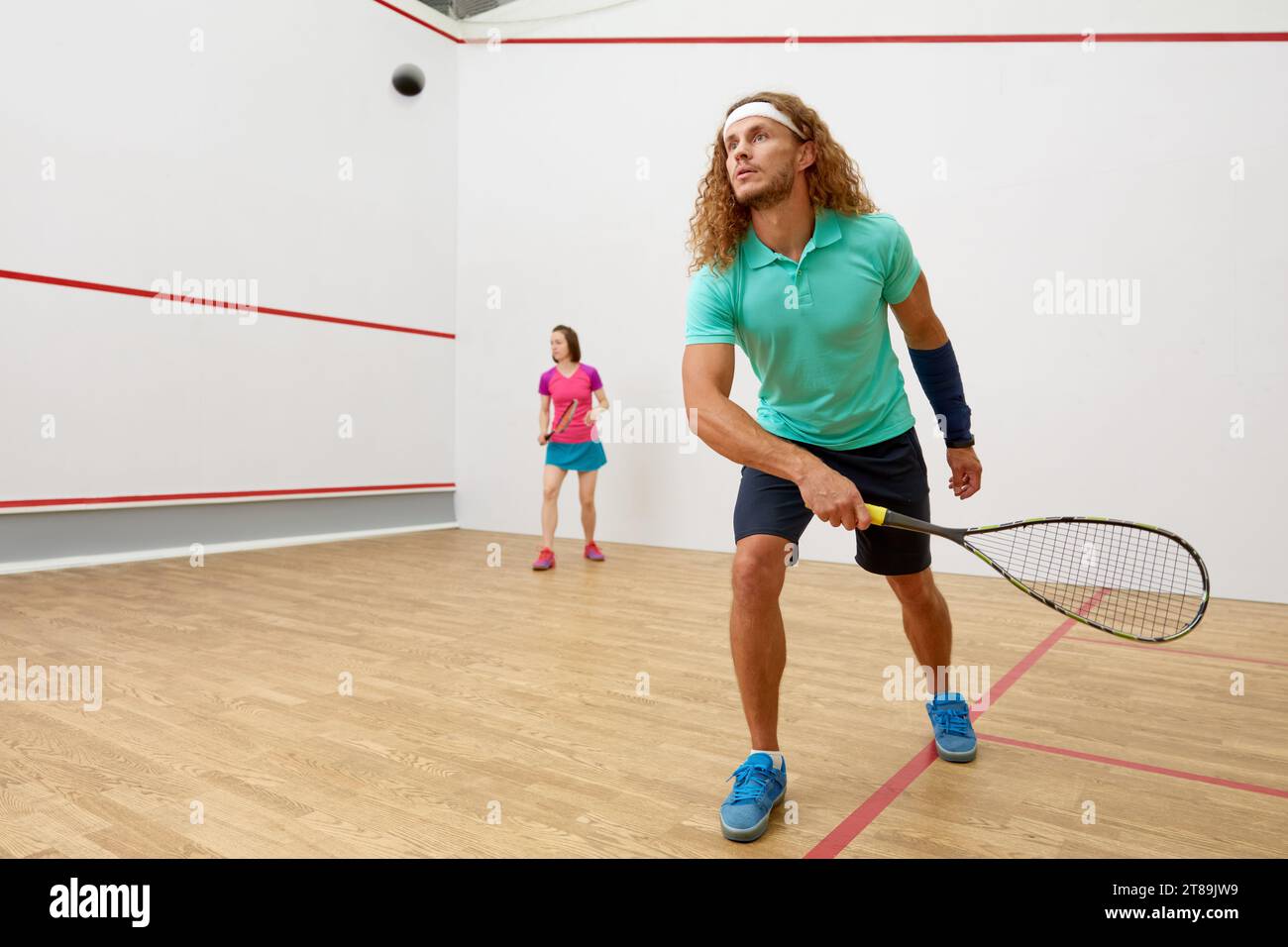 Squash male player with racket playing game with female friend Stock ...