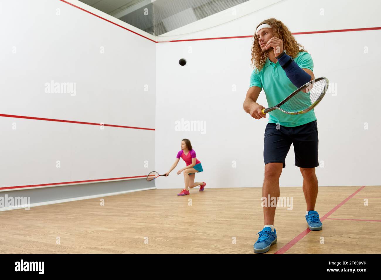 Happy millennial-age couple characters playing game of racquetball ...