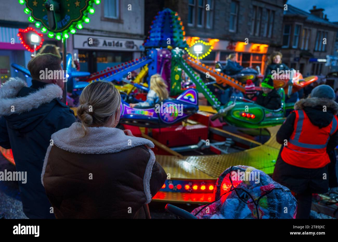 Crowds enjoying a funfair in the street at a Christmas street market in ...