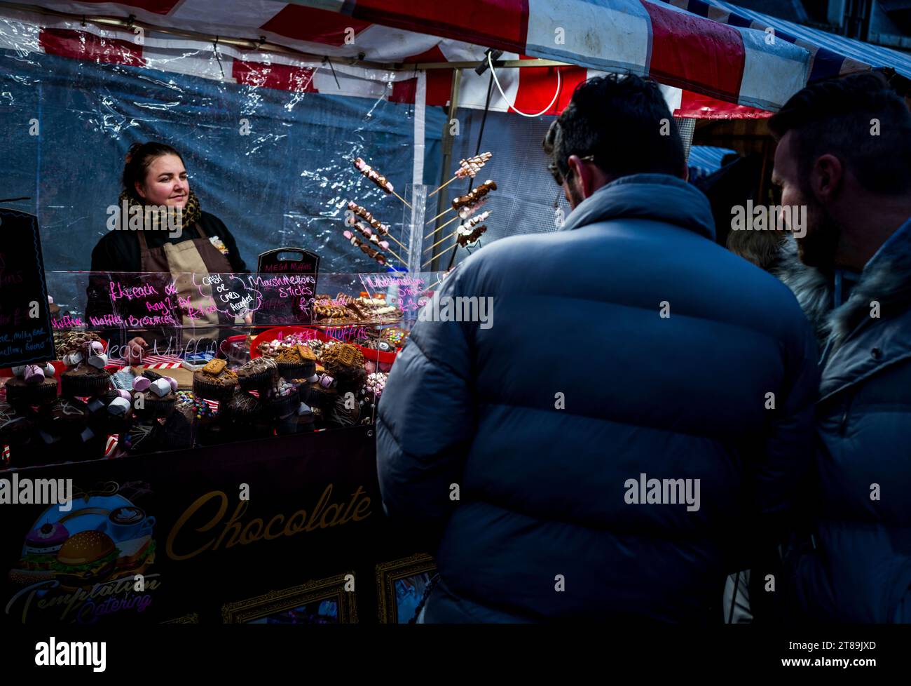 Customers at a stall selling chocolate sweets at a Christmas street ...