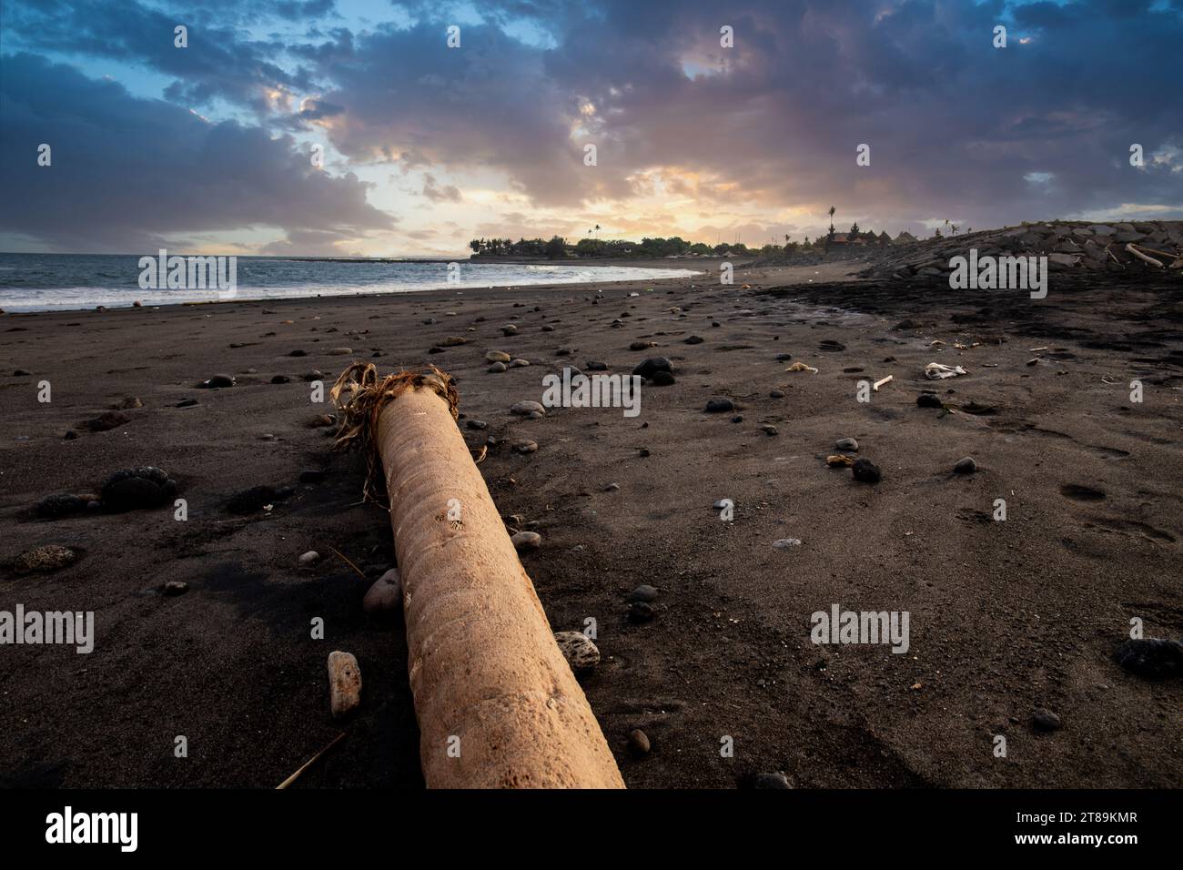 Hindu temple on a black sand beach directly by the sea. Evening ...