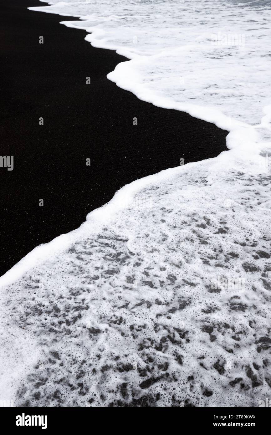 Black sand beach in Bali, with white waves and spray. lava sand beach ...