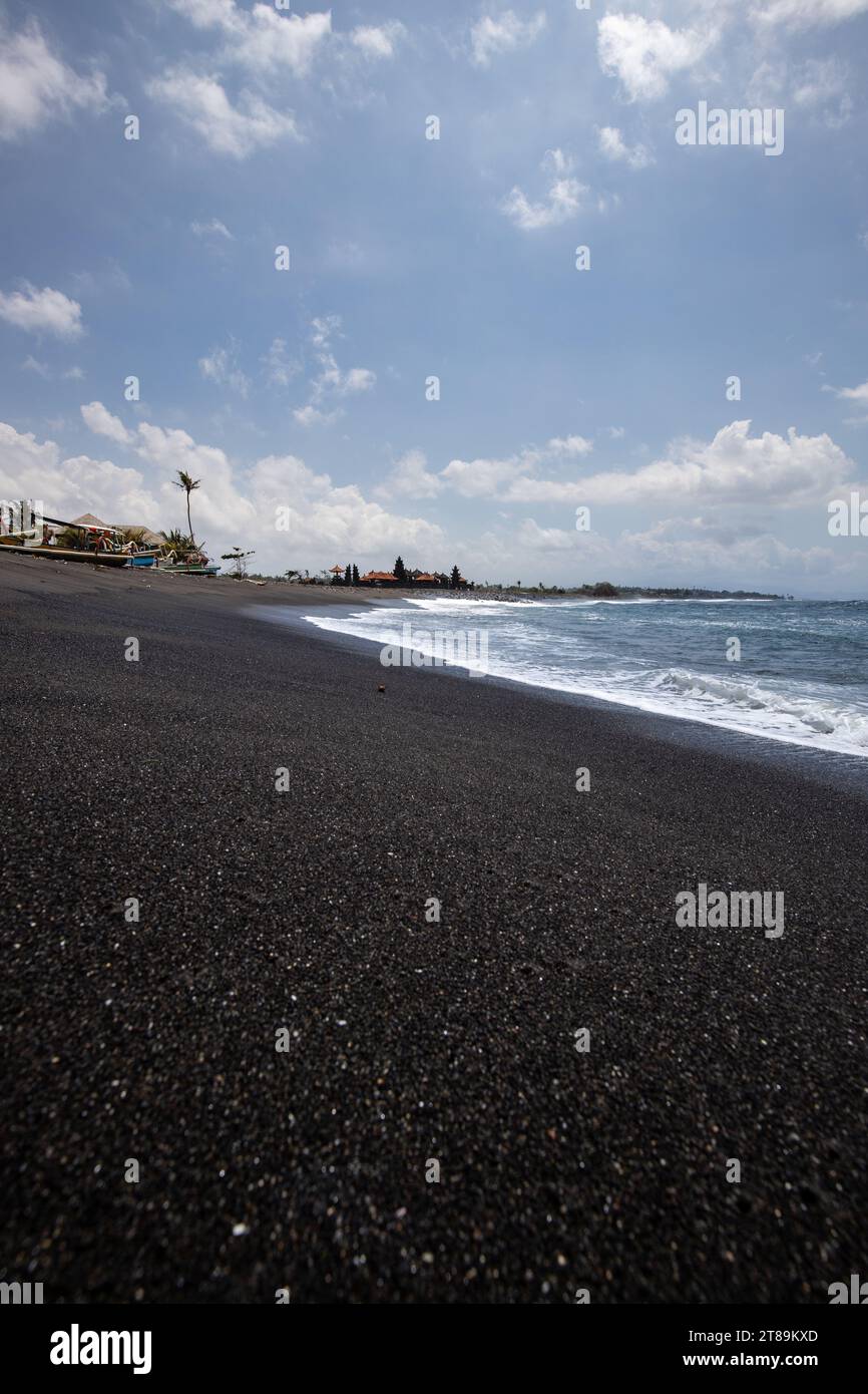 Black sand beach in Bali, natural with temples, boats (jukung) and ...