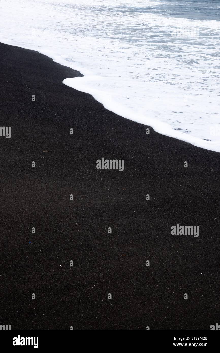 Black sand beach in Bali, with white waves and spray. lava sand beach ...