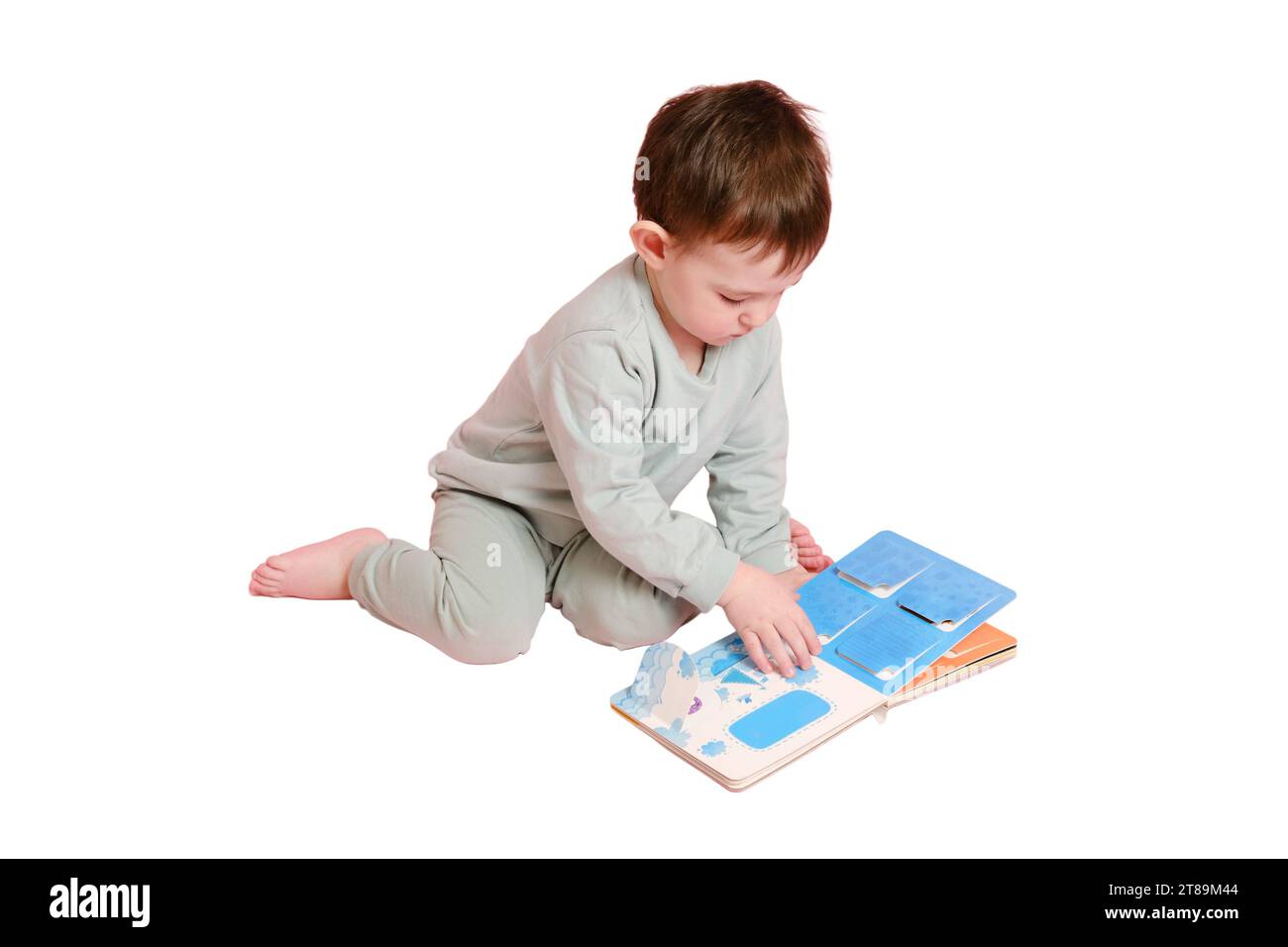 Happy toddler baby is reading a book on studio, isolated on white ...