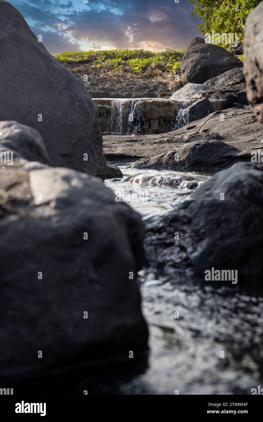 Black sand beach in Bali, with white waves and spray. lava sand beach ...