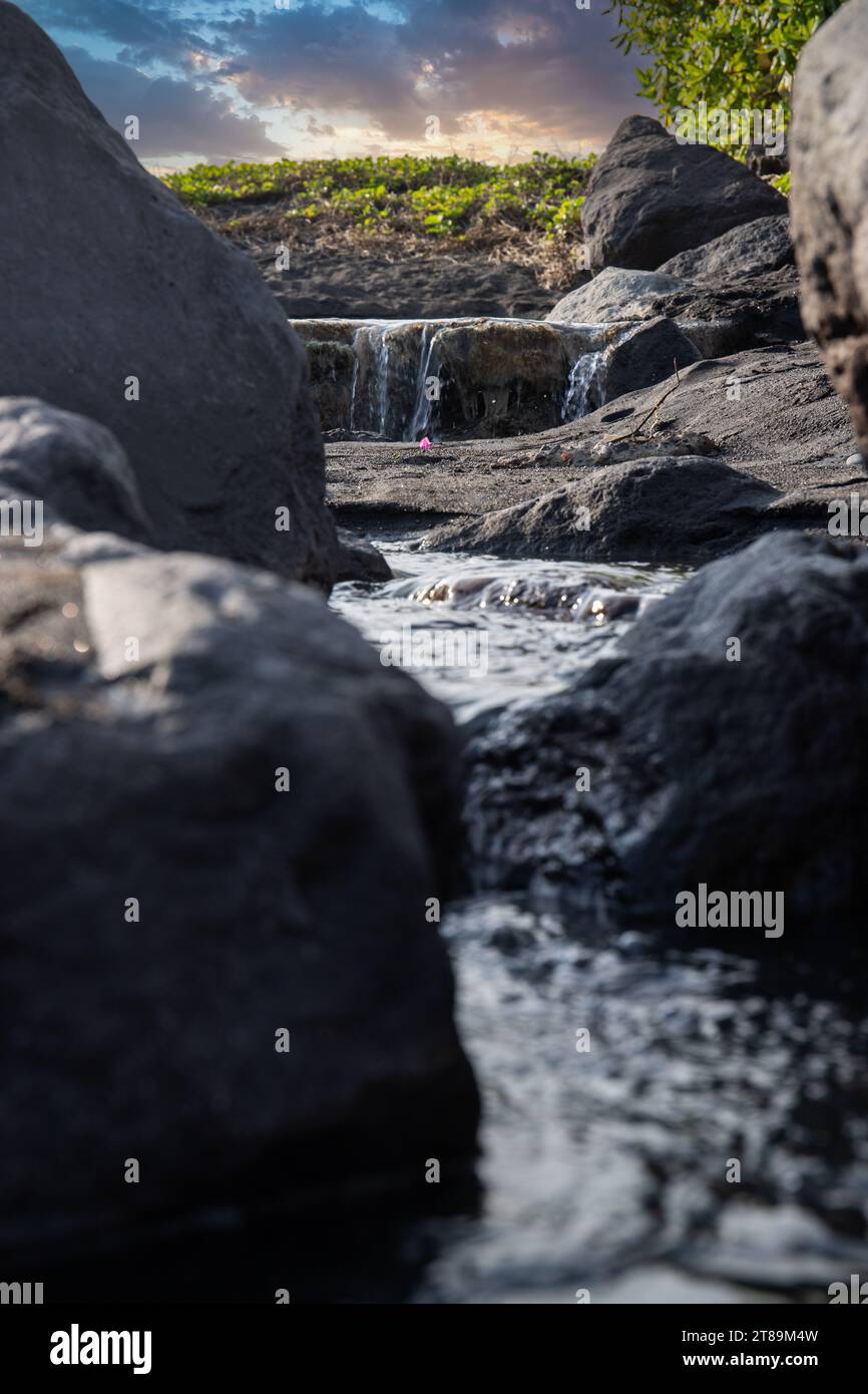 Black sand beach in Bali, with white waves and spray. lava sand beach ...