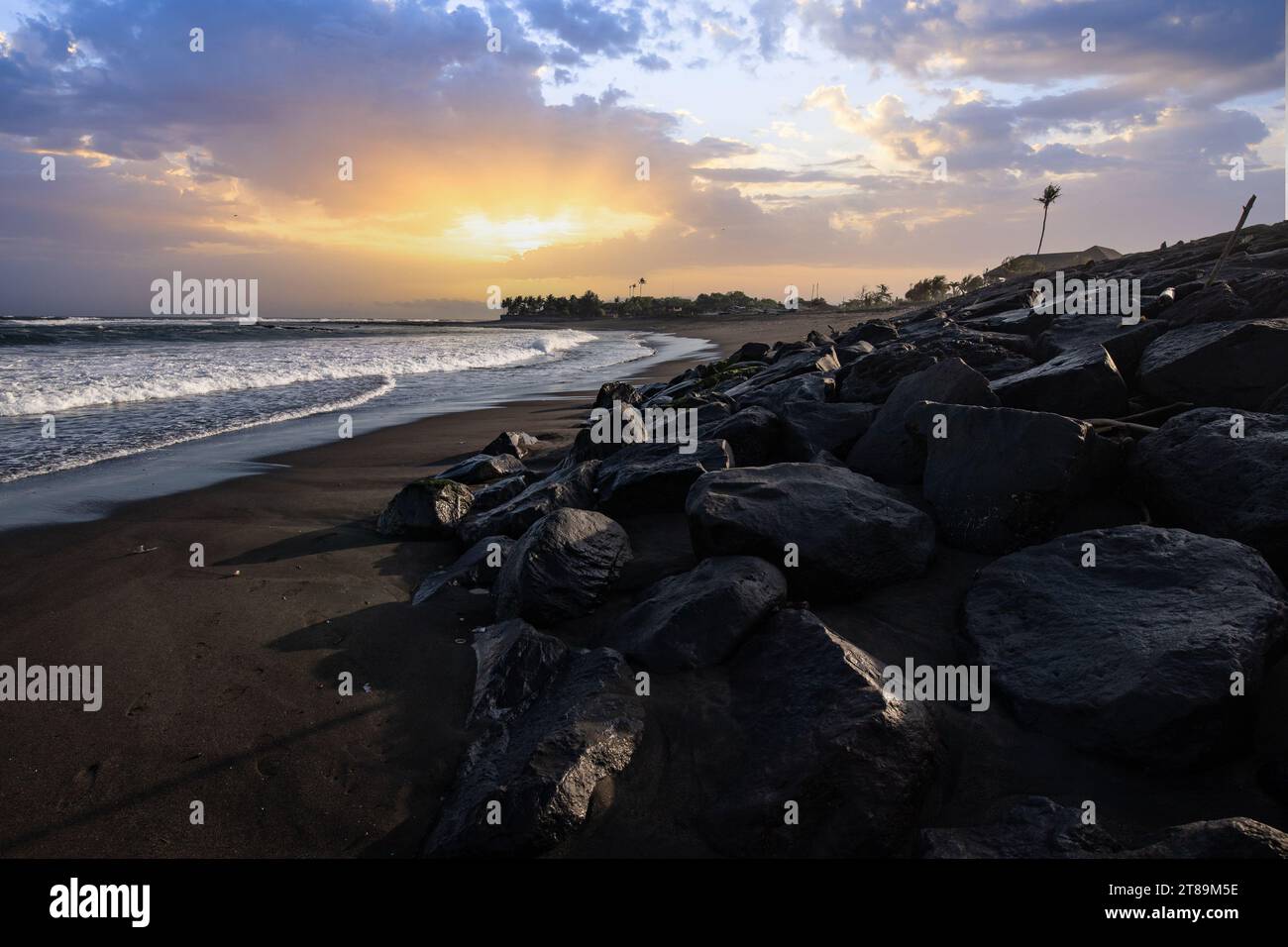 Hindu temple on a black sand beach directly by the sea. Evening ...