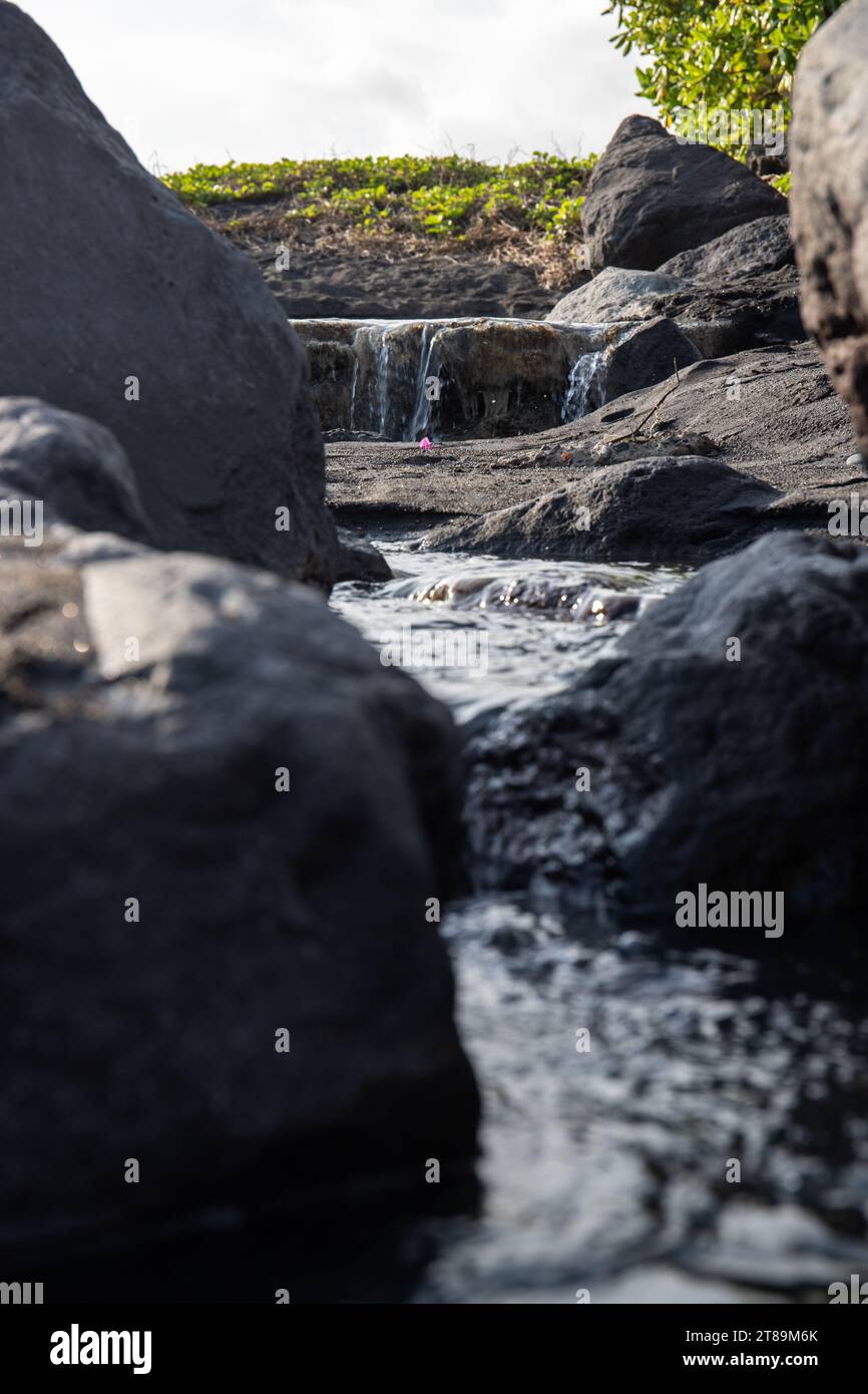 Black sand beach in Bali, with white waves and spray. lava sand beach ...