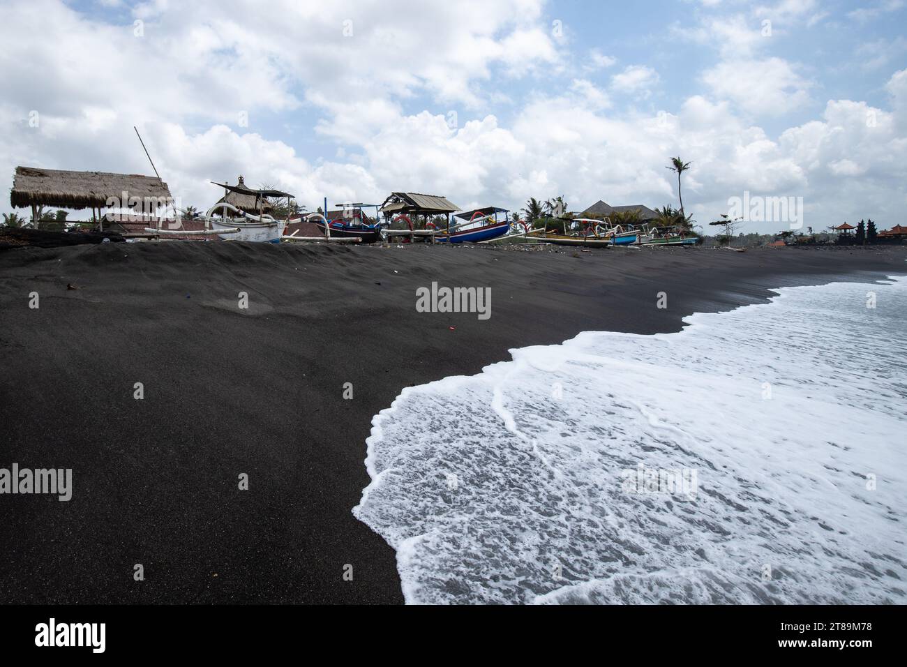 Black sand beach in Bali, natural with temples, boats (jukung) and ...
