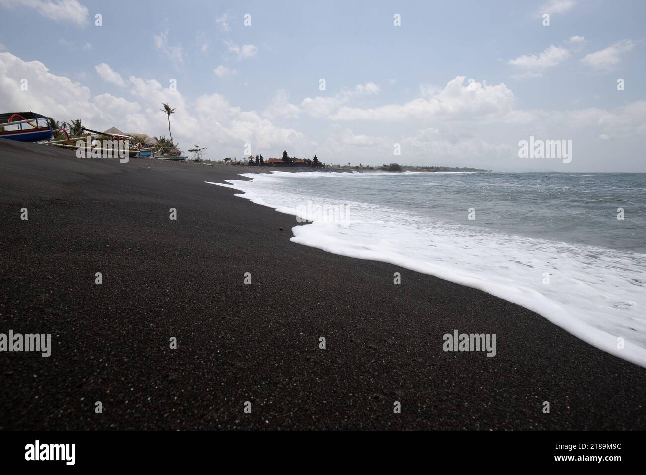 Black sand beach in Bali, natural with temples, boats (jukung) and ...