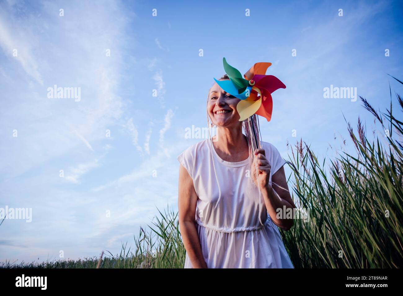 girl with multicolored pigtails , face sideways, laughing, holding a ...