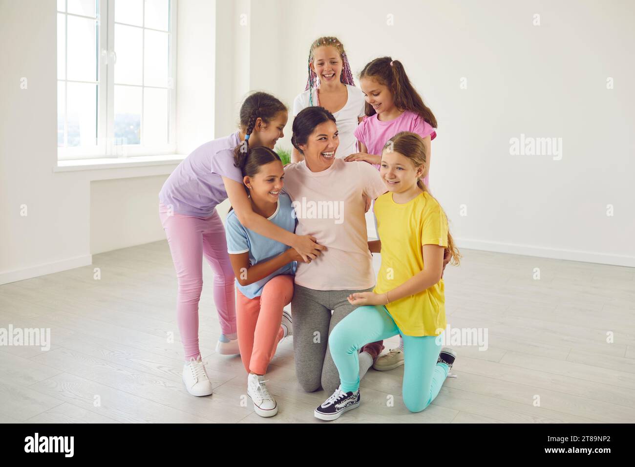 Happy girls dancers with theer teacher choreographer hugging together ...