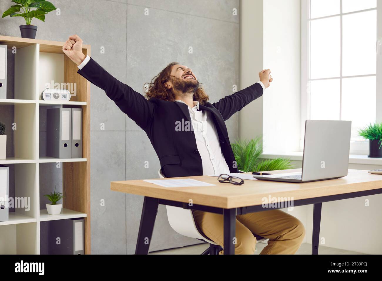Relaxed business man stretching at the desk on workplace in office ...