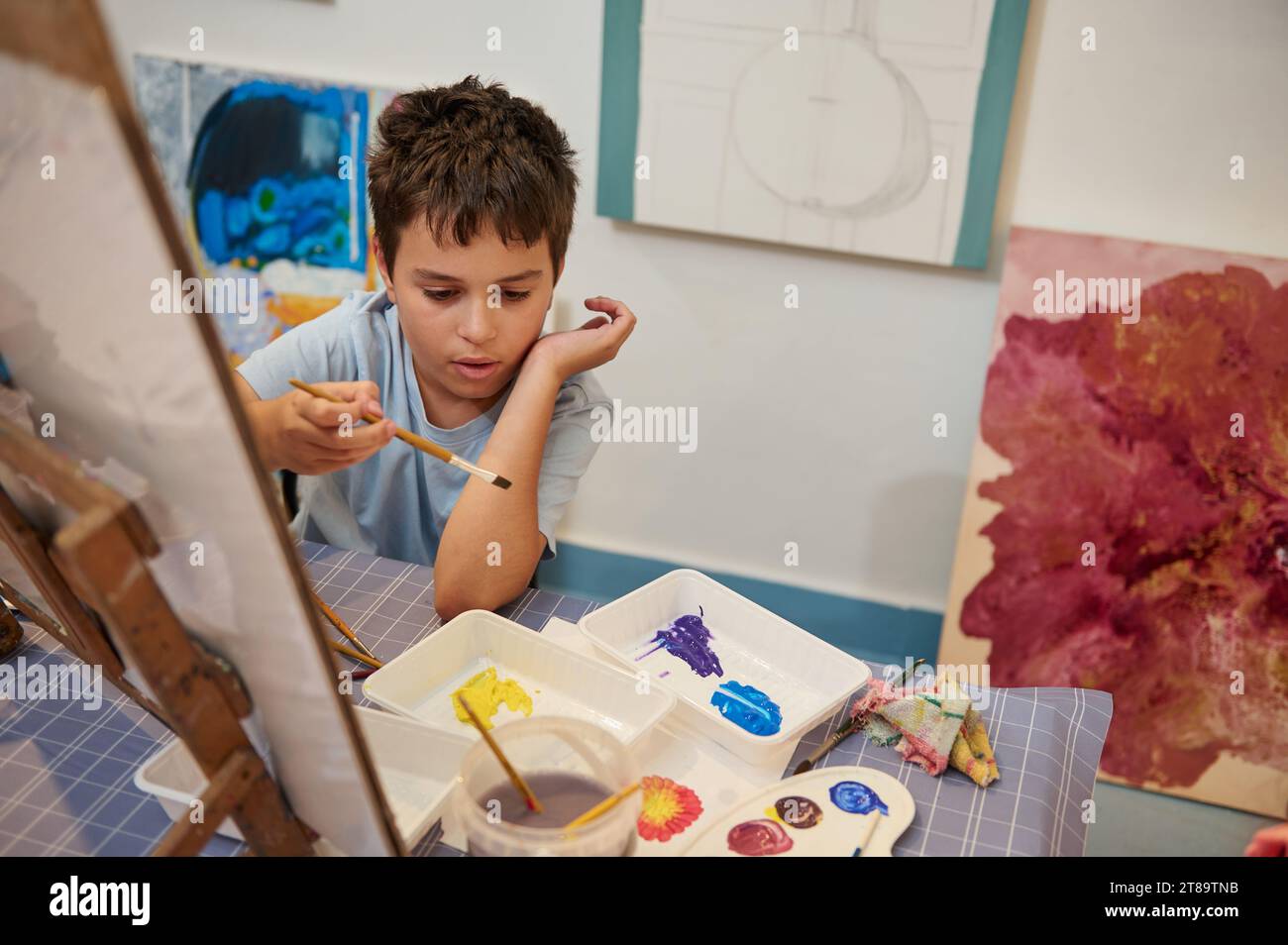 Authentic confident Caucasian teenage boy drawing picture at art class ...
