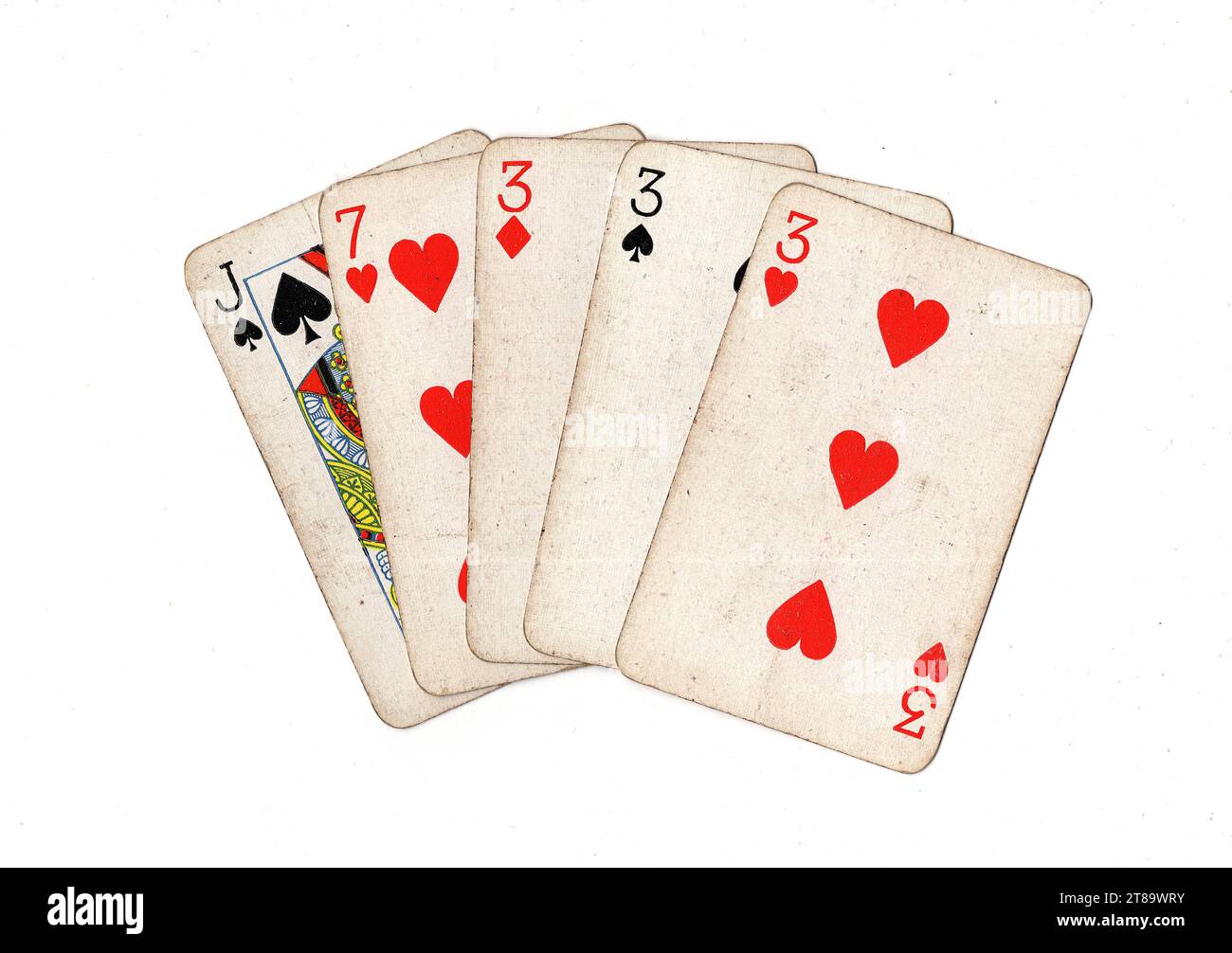 A poker hand of vintage playing cards showing three threes on a white ...
