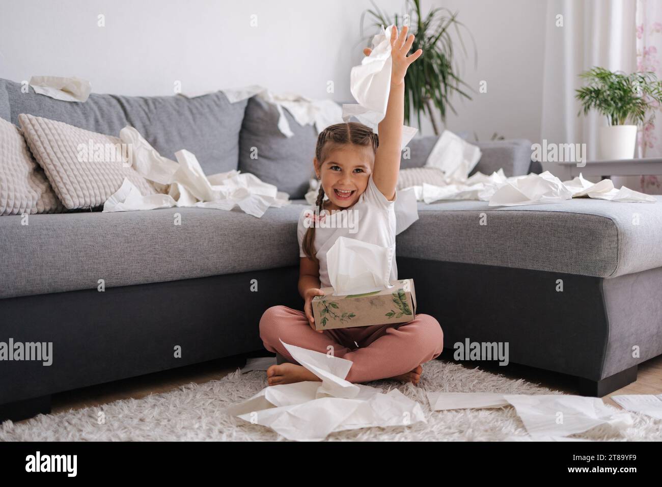 The process of creating a mess by a child. Little girl scatters napkins ...