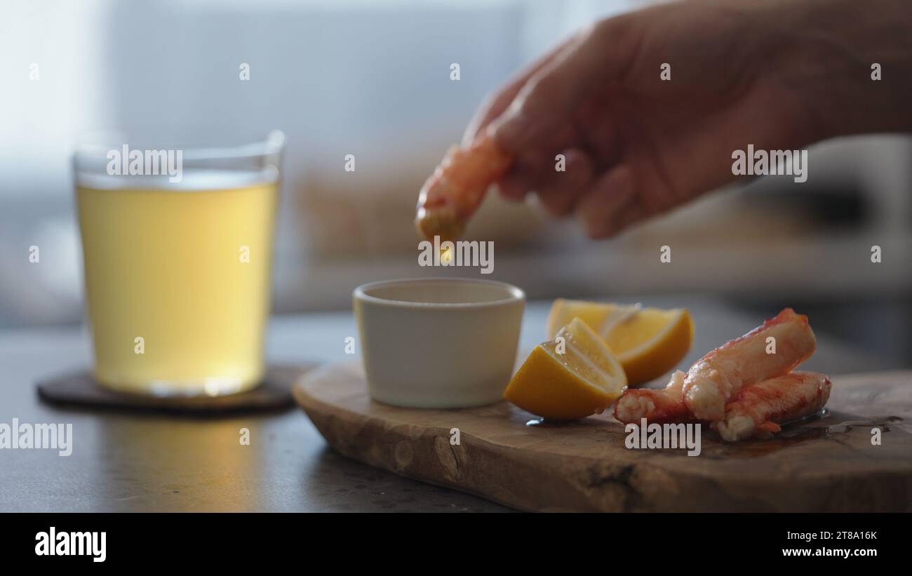 Man dip crab leg into pesto sauce with ginger beer on background, wide ...
