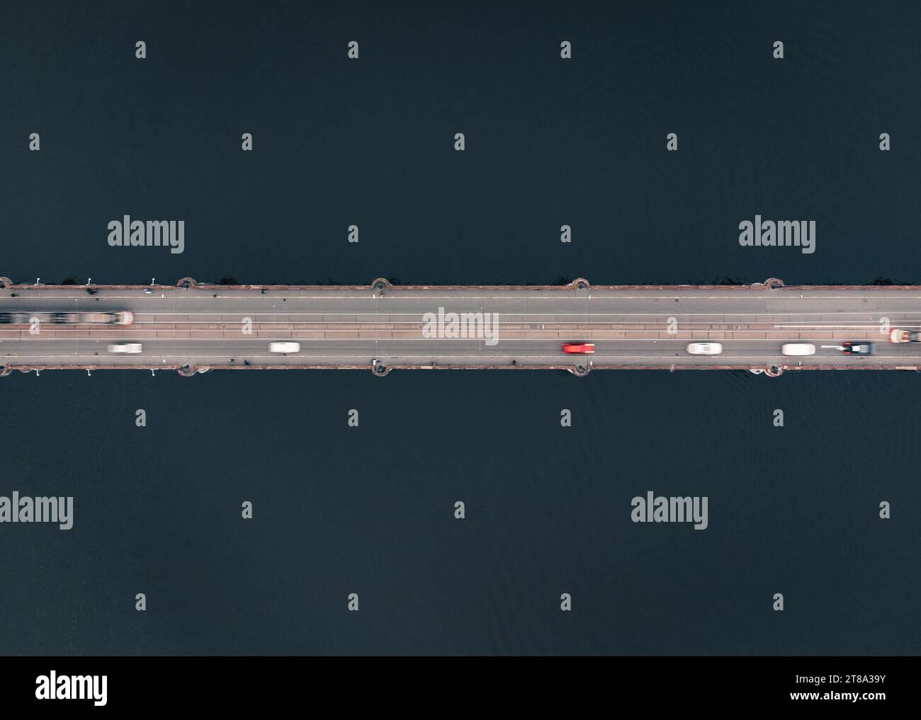 Aerial top view drone shot of bridge with cars and tram and blue water ...