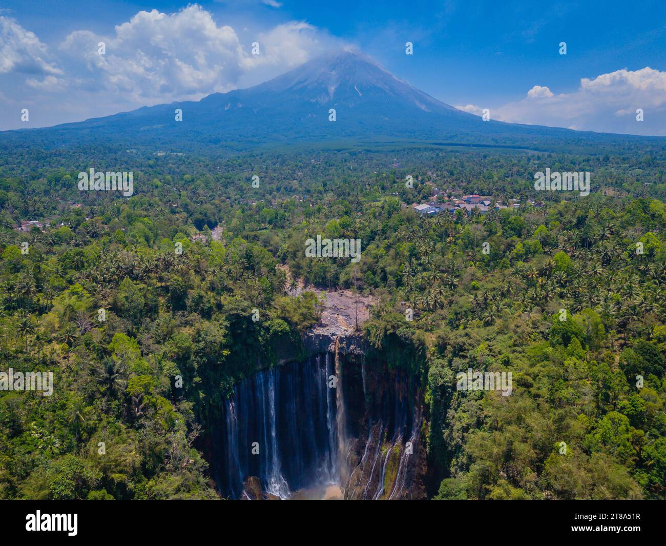 Aerial view of the Tumpak Sewu waterfall and Semeru volcano and jungle ...