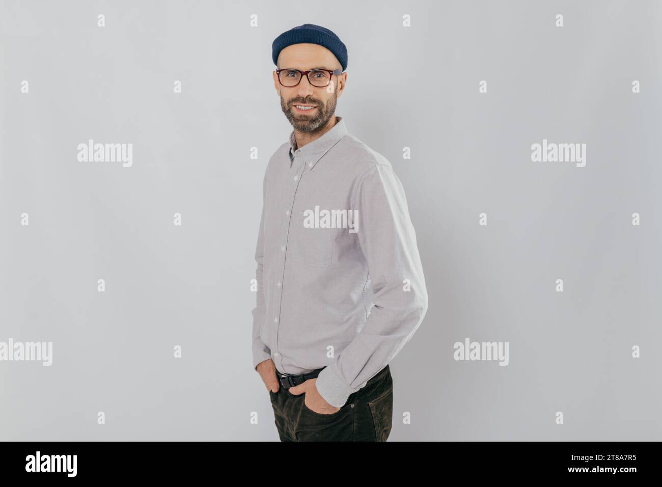 Profile shot of attractive unshaven man dressed formally, wears optical ...