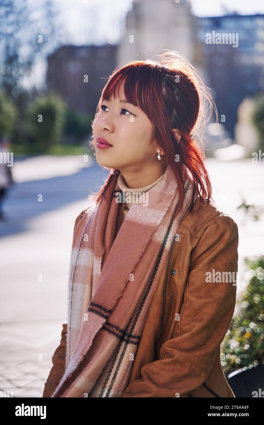 Young confident smiling Asian woman standing on street, portrait. Proud ...