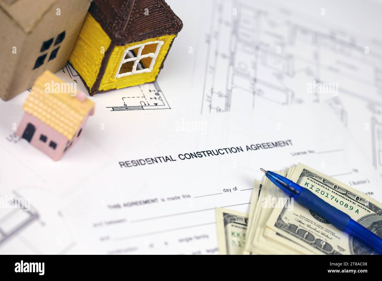 Residential construction agreement ready to sign with small toy houses ...