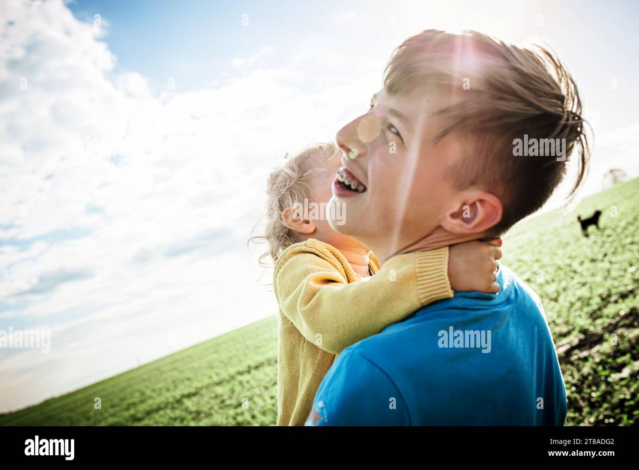 A little girl hugs a boy while walking in nature. Family on a walk in ...