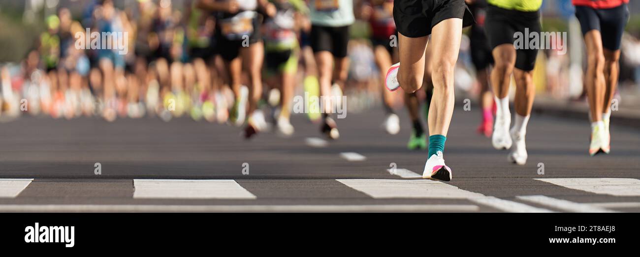 Marathon runners running on city road, large group of runners, close-up ...