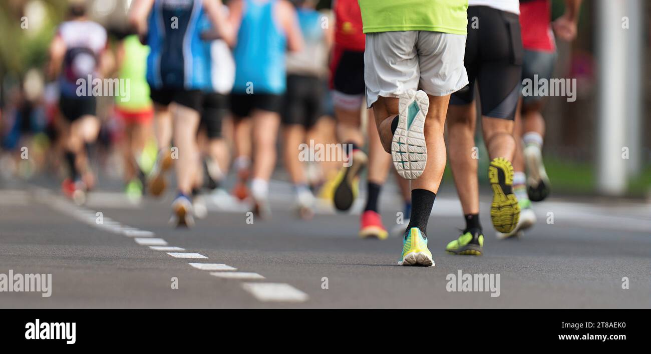 Marathon runners running on city road, large group of runners, close-up ...
