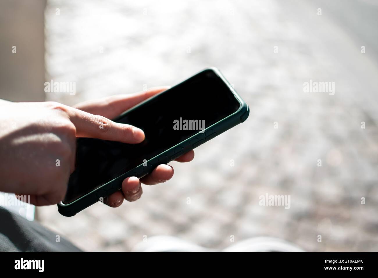 Close up view of hands using cell phone with body seated background on ...