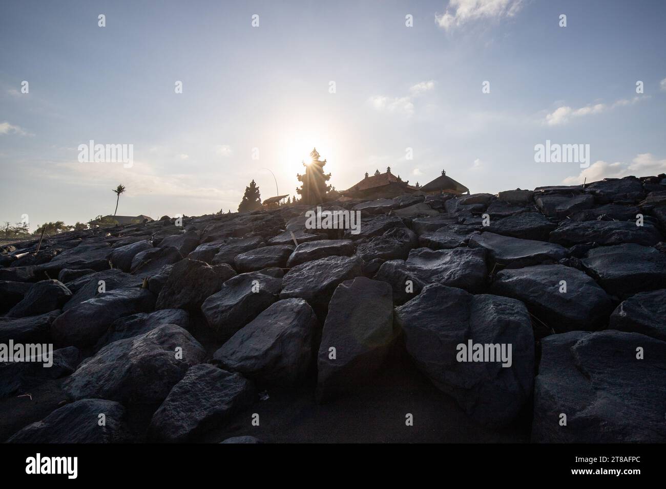 Hindu temple on a black sand beach directly by the sea. Evening ...