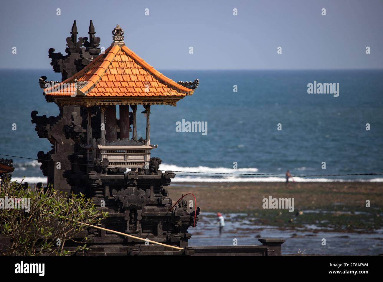 Hindu temple on a black sand beach directly by the sea. Evening ...