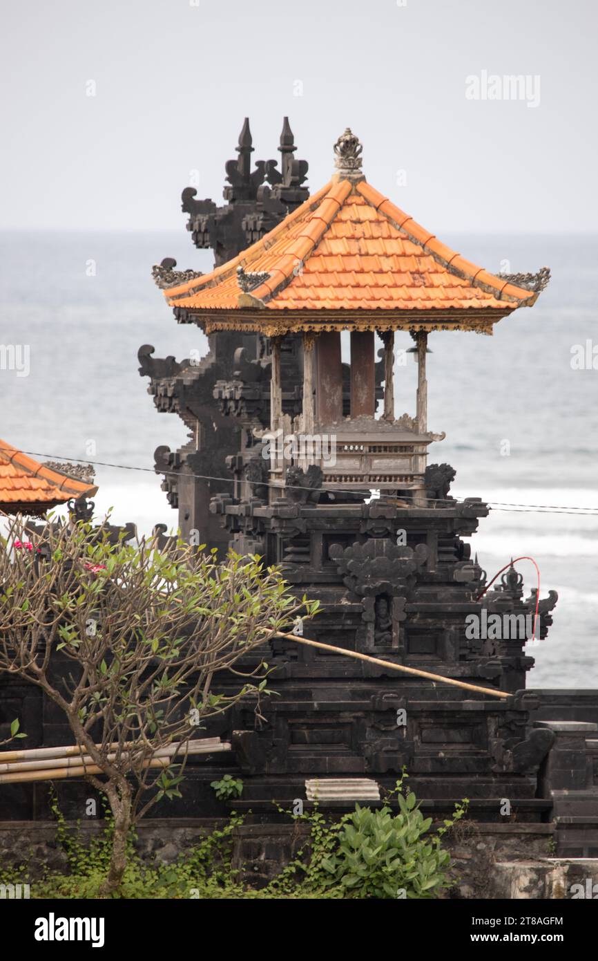 Hindu temple on a black sand beach directly by the sea. Evening ...
