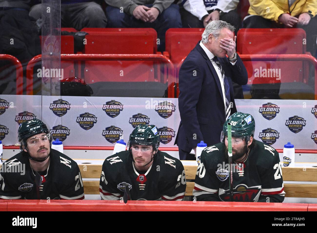 Minnesota's head coach Dean Evason, standing, reacts as players Brandon ...