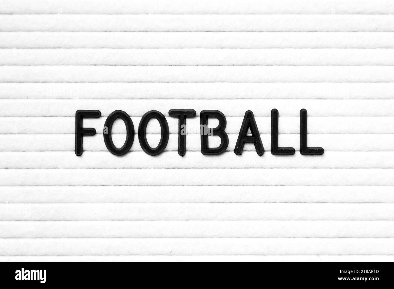 Black color letter in word football on white felt board background ...