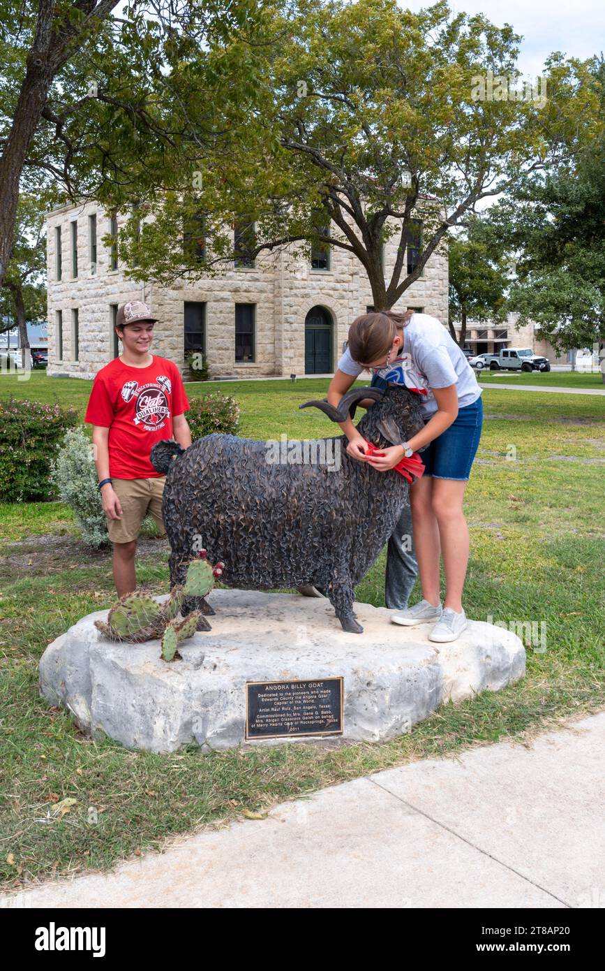 Student ties a red ribbon around the neck of Angora billy goat statue ...
