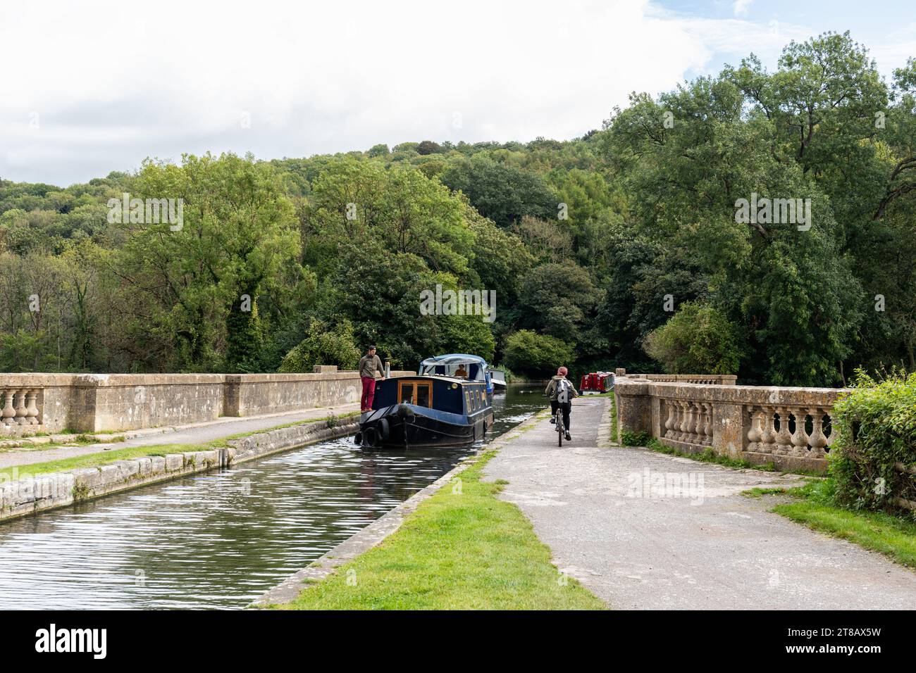 Narrowboat and cyclist on the Dundas Aqueduct which carries the Kennet ...