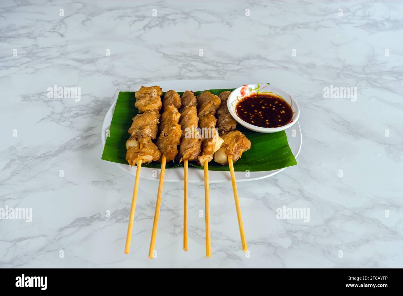 Grilled crocodile steak with Thai spicy dipping sauce or Jaew sauce on ...