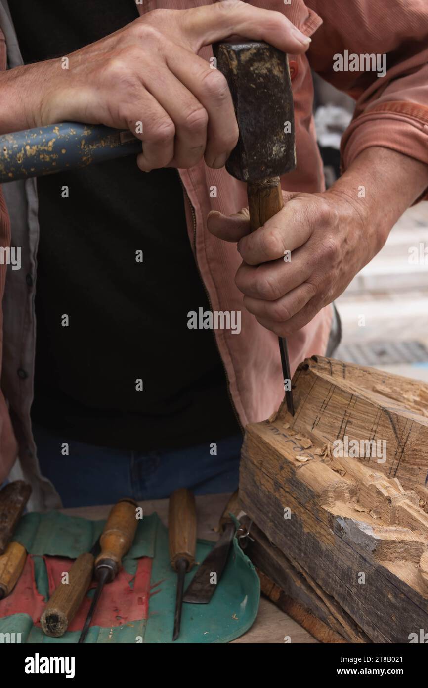 a man makes products from a tree with his own hands and with a tool ...