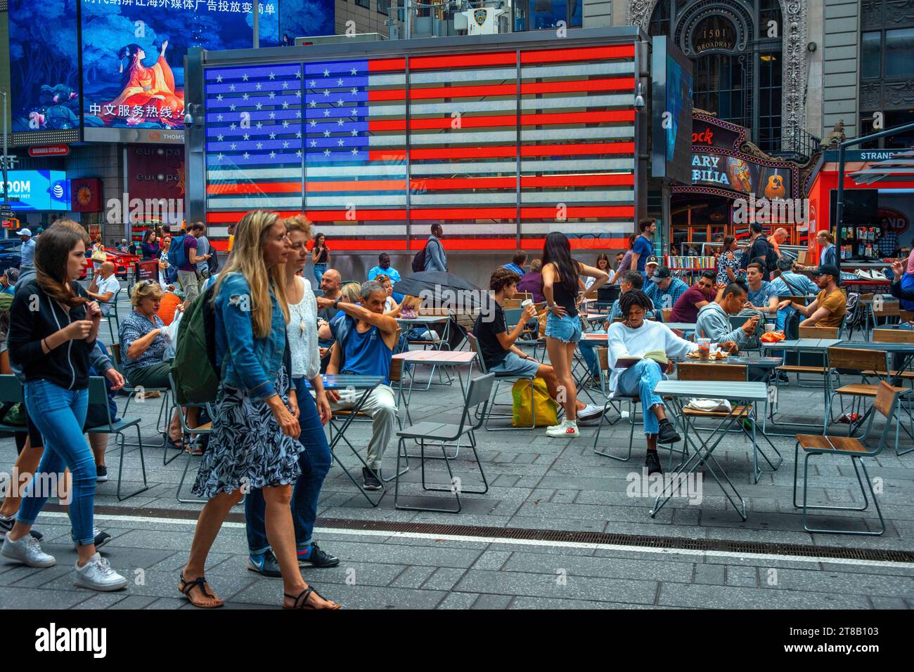 Big american flag in Times Square, New York City at night. Crowds in ...