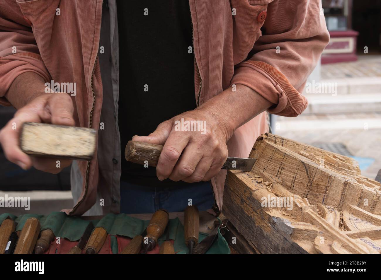 a man makes products from a tree with his own hands and with a tool ...