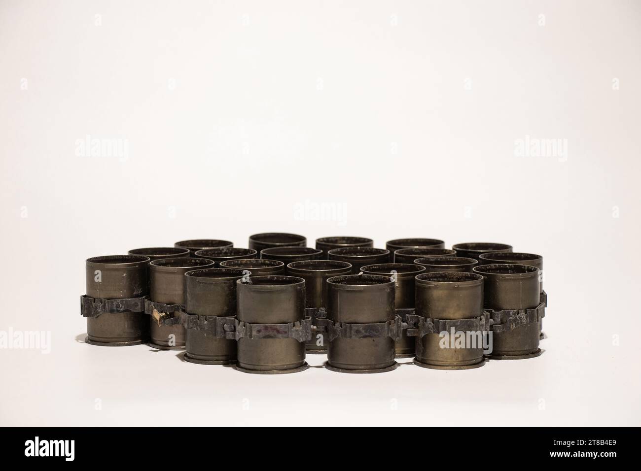 Ribbon of automatic grenade launcher casings on a white background, an ...