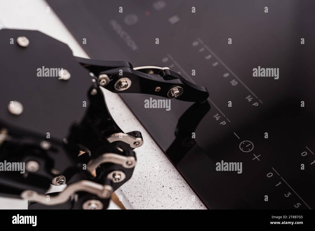 Real robot's hand and induction electric stove. Concept of robotic ...